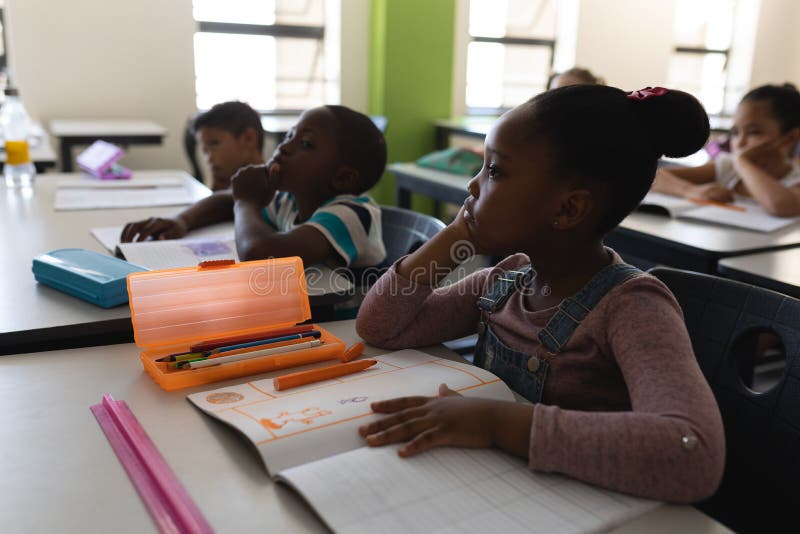 Side View of Schoolkids Studying and Sitting at Desk in Classroom Stock ...
