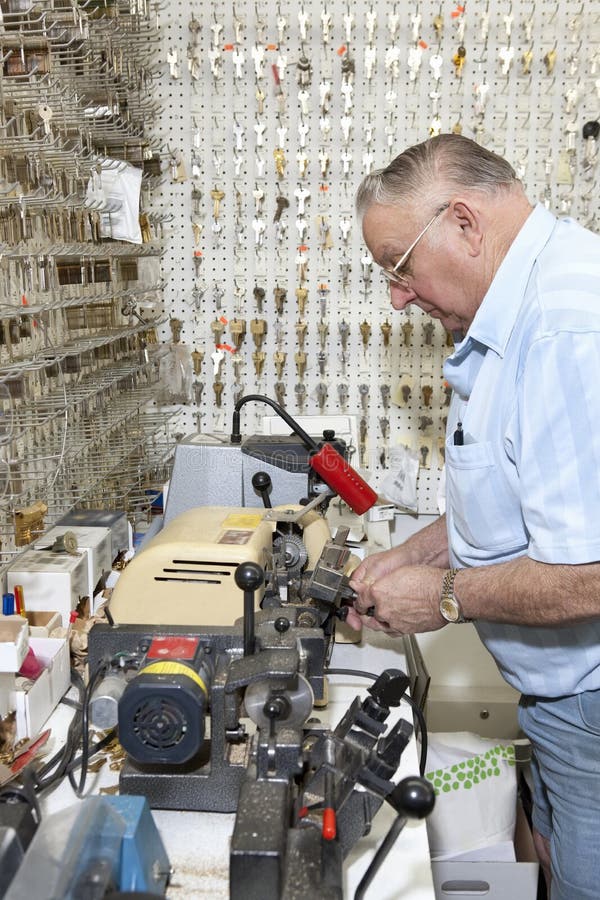 Side View of Senior Locksmith Making Key in Store Stock Photo - Image ...