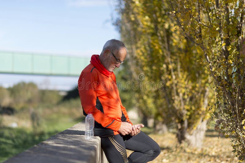 Side View of a Senior Runner Man Leaning on Fence while Testing ...
