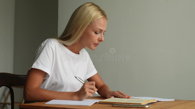 Side View of Serious Blonde Young Woman Student Learning Making Notes ...