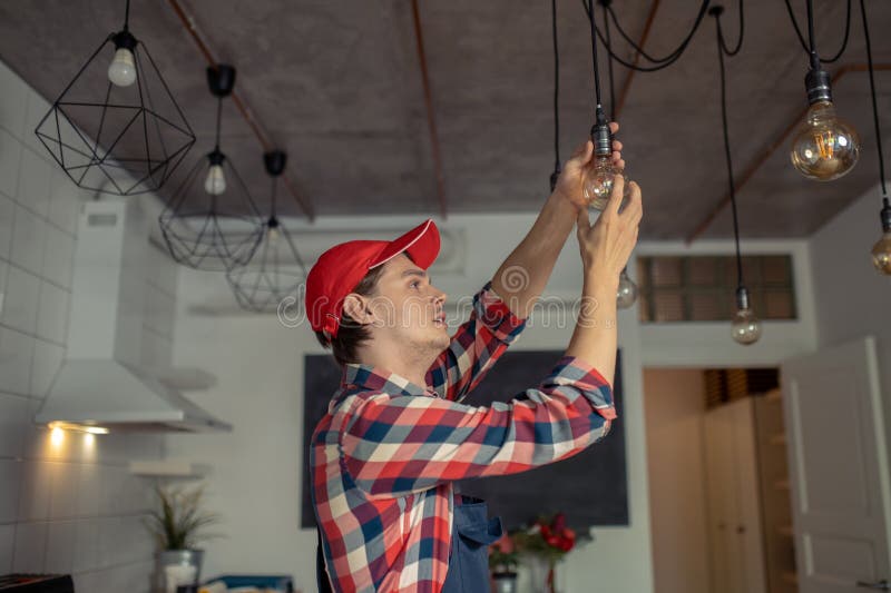 Young Electrician Changing the Electric Bulb on the Ceiling Stock Image ...