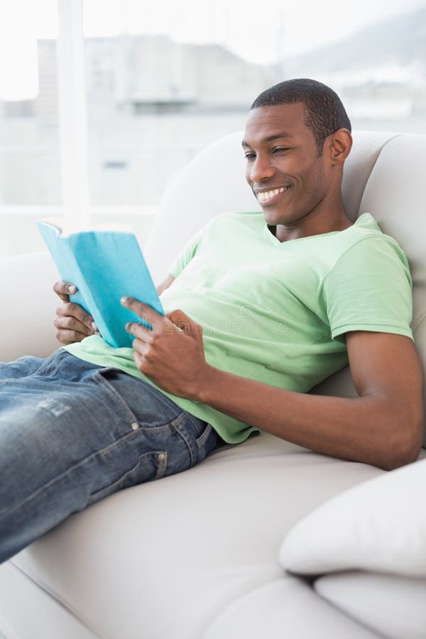 Side View of Smiling Afro Man Reading a Book on Sofa Stock Image ...