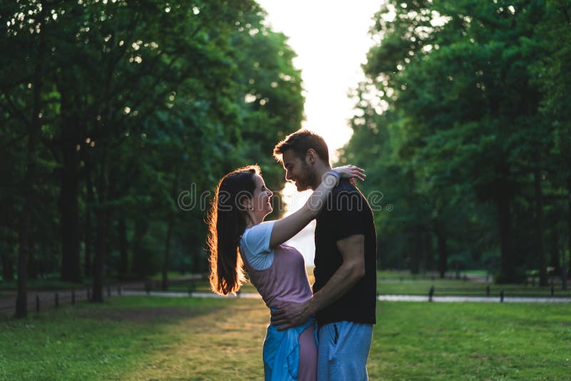Side View of Smiling Couple Embracing Each Other on Meadow Stock Image ...