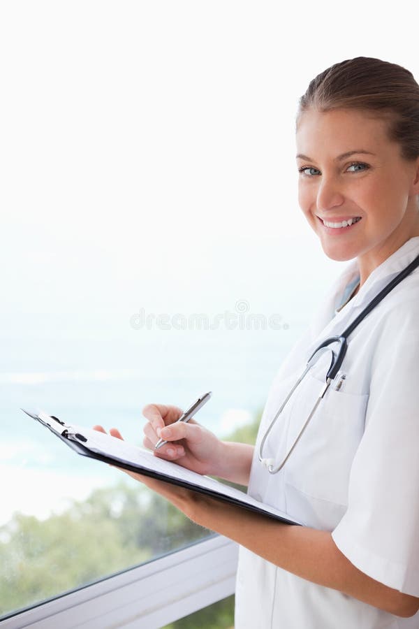 Side View of Smiling Doctor with Clipboard Stock Photo - Image of care ...
