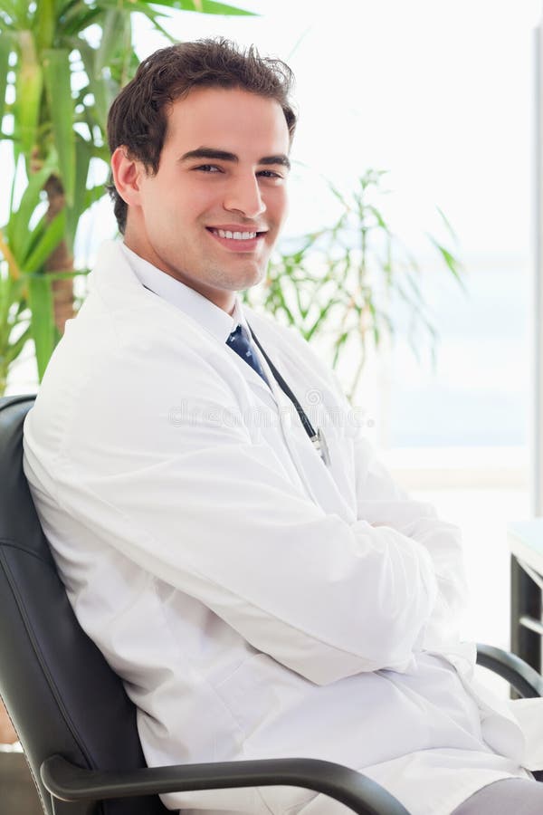Side View of Smiling Doctor Sitting Stock Photo - Image of uniform ...