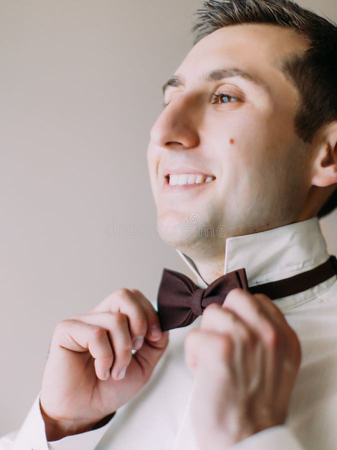 Side View of the Smiling Groom Correcting the Bow-tie. Stock Photo ...