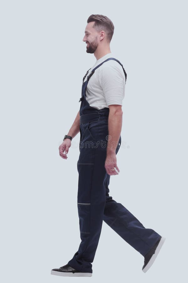 Side View. Smiling Man in Overalls Confidently Striding Forward Stock ...