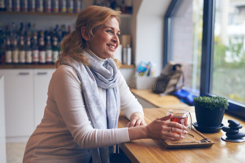Smiling Woman Enjoying Cup of Tea in Cafe Stock Photo - Image of side ...