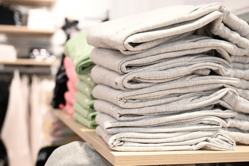 Side View of Stack of Clothes Lies on the Store Shelf. Clothes Sale ...