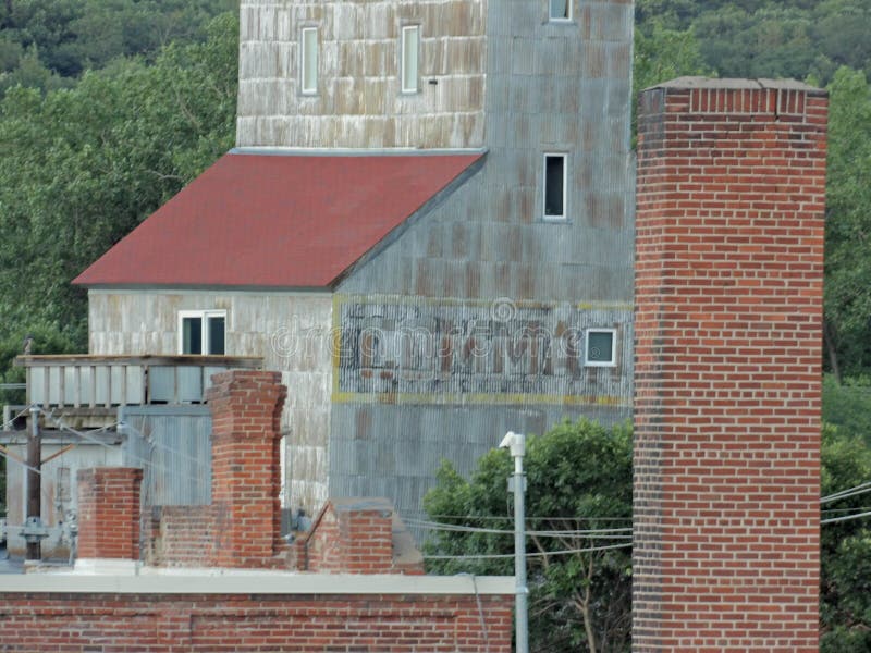 Side View of a Tall Cement Silo Situated beside Two Brick Pillars and a ...