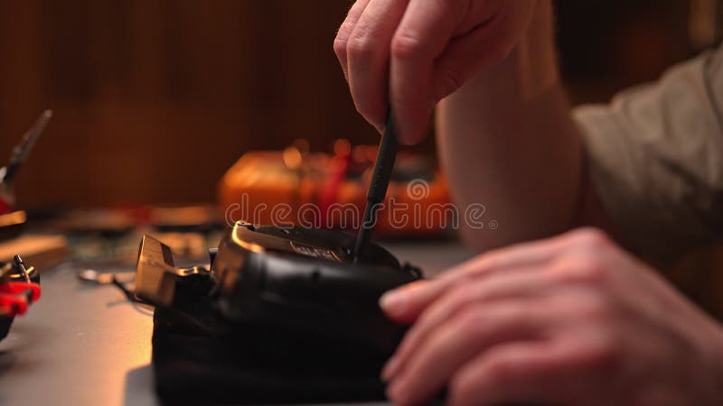 Side View of Technician Hands Using Screwdriver To Disassemble and Repair Drone Remote Control ...