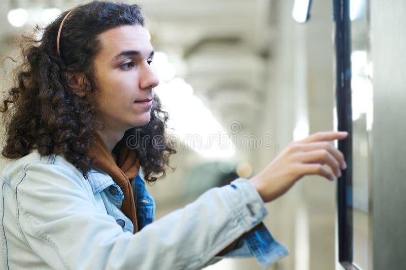 Side View of Teenager in Denim Jacket Pointing at Display with ...