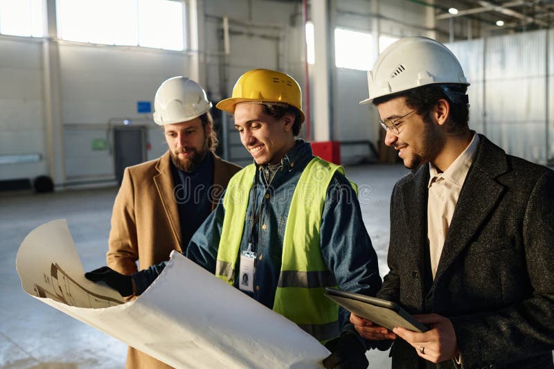 Side View of Three Young Successful Architects Discussing Points of ...