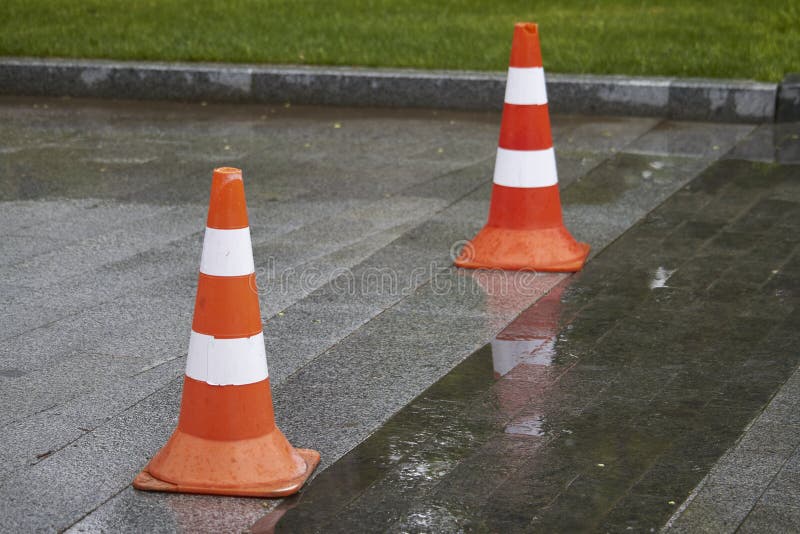 Side View of Two Bright Orange-white Warning Cones on Brick Pavement ...