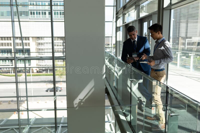 Side View of Two Businessman Looking Down a Digital Tablet at the First ...