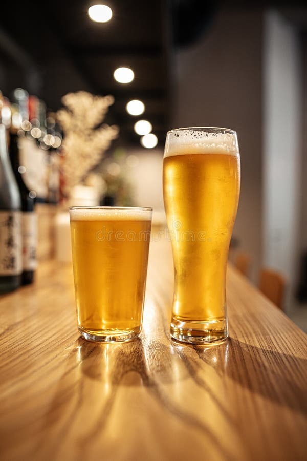 Two Glasses of Japanese Light Beer on a Bar Desk Stock Image - Image of ...