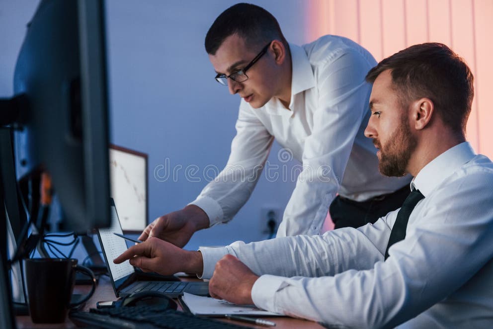 Side View. Two Stock Traders Working in the Office with Exchange ...