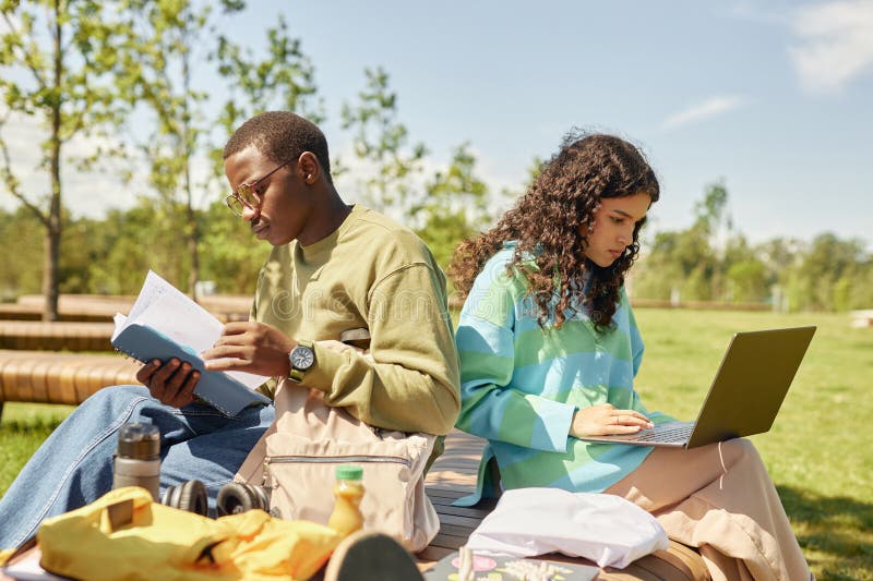 Side View Two Students on Bench Studying Using Laptop and Notebooks ...