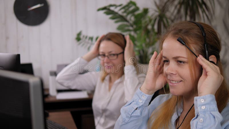 Side View of Two Young Friendly Female Operators Putting on Headsets in ...