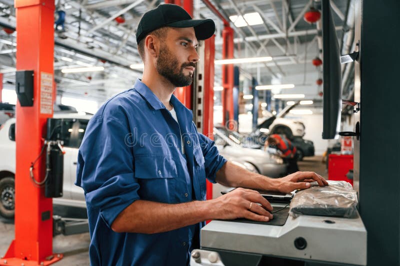 Side View, Using Computer. Auto Mechanic Working in Garage Stock Image ...
