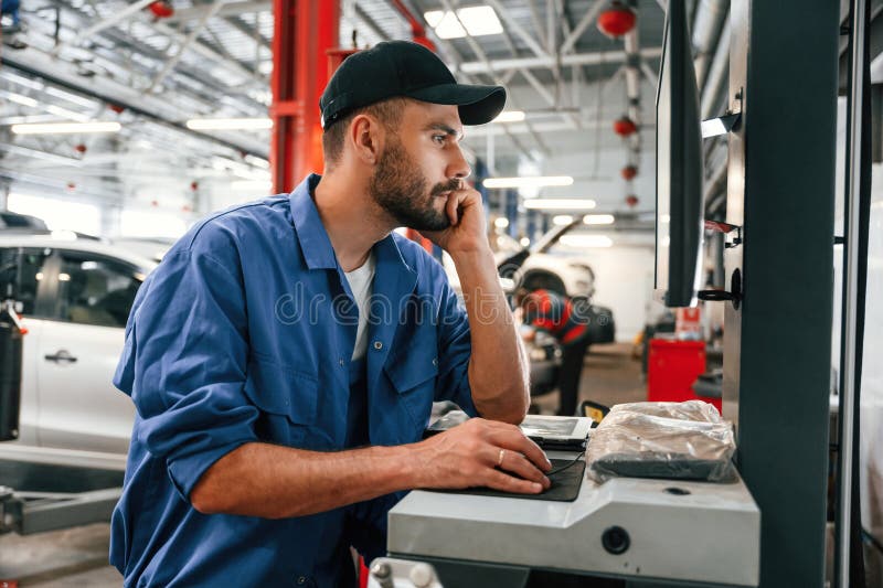 Side View, Using Computer. Auto Mechanic Working in Garage Stock Image ...