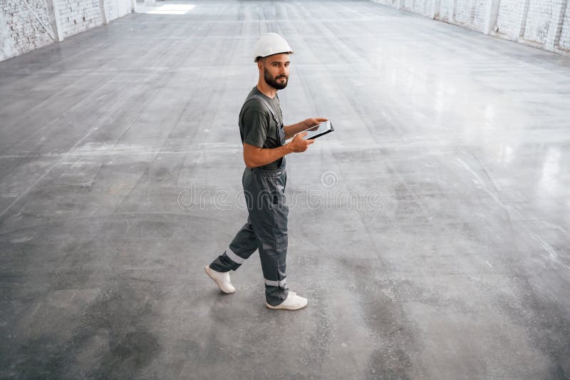 Side View, Using Digital Tablet. Male Worker is in the Empty Warehouse ...