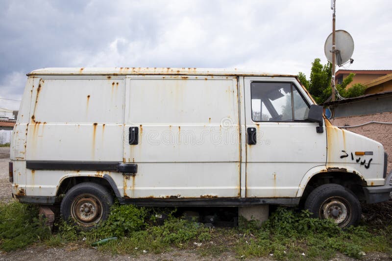 Side View of a Very Old, Rusty, Abandoned Van. it is Off the Ground and ...