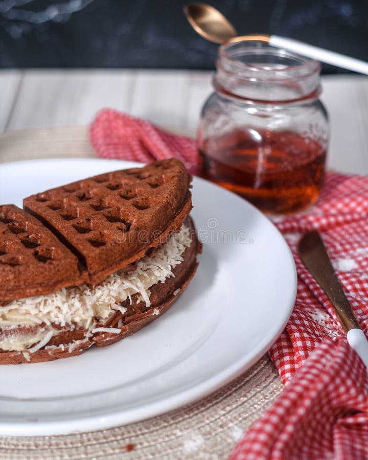 Side View of a Waffle Being Smeared with Vanilla Cream on a White Plate ...