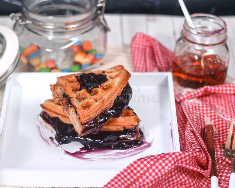 Side View of Waffles Stacked on a White Table with and Tea Mug As the ...