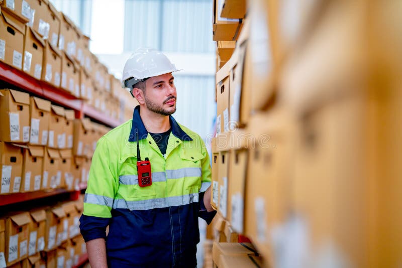 Side View Warehouse Worker Man Stand in Front of the Shelves and Look ...