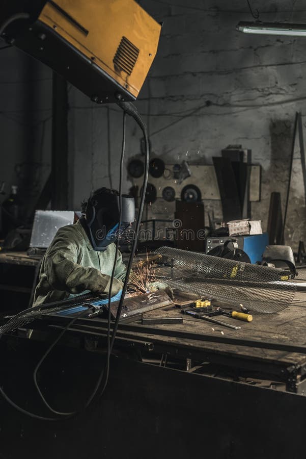 Side View of Welder in Protective Work Wear Working with Welding Torch ...