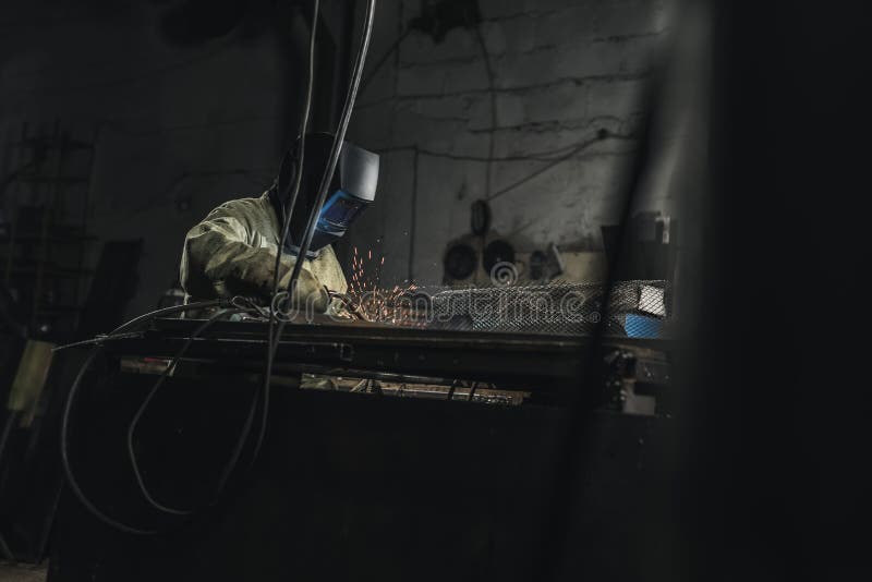 Side View of Welder in Protective Work Wear Working with Welding Torch ...