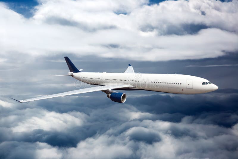 The Passenger Plane Flies High between the Clouds Layers Stock Photo ...