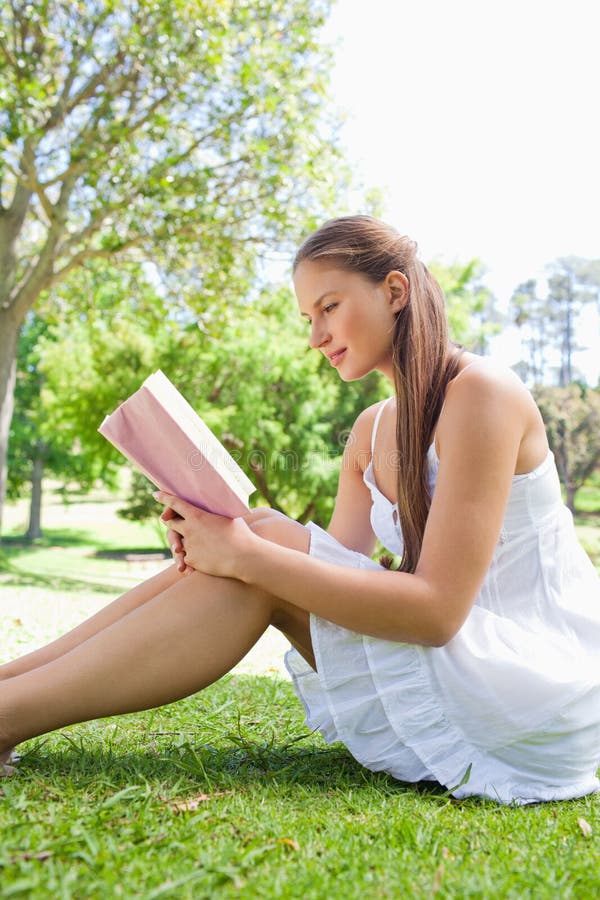Side View of a Woman Reading a Book on the Grass Stock Image - Image of ...