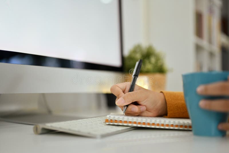 Side View of Woman Sitting in Front of Computer Monitor and Writing ...