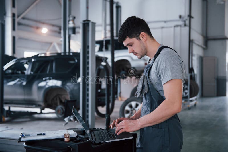 Side View. Worker Stands Indoors in Uniform Does Reports, Calculations ...
