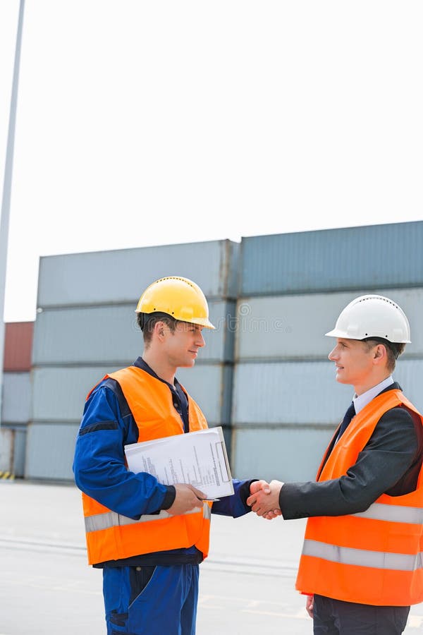 Side View of Workers Shaking Hands in Shipping Yard Stock Image - Image ...