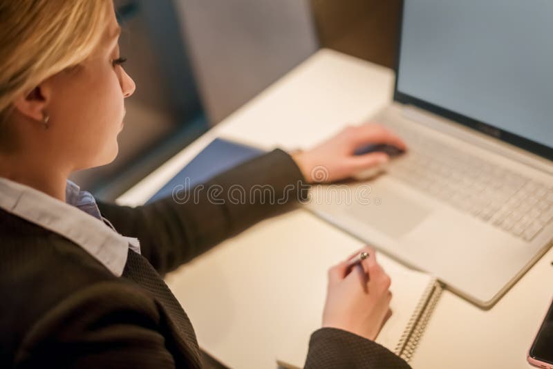 Side View. Young Business Woman Sitting at Table and Taking Notes in ...