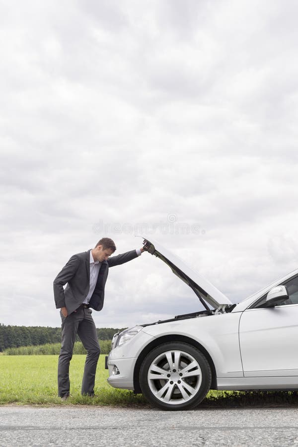 Side View of Young Businessman Examining Broken Down Car Engine at ...
