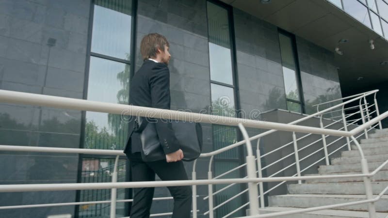Side View of Young Businessman Walking in Passage of Office with Laptop ...
