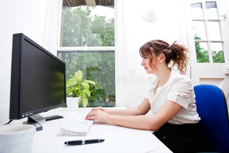 Side View of Young Businesswoman Using Computer at Desk Stock Image ...
