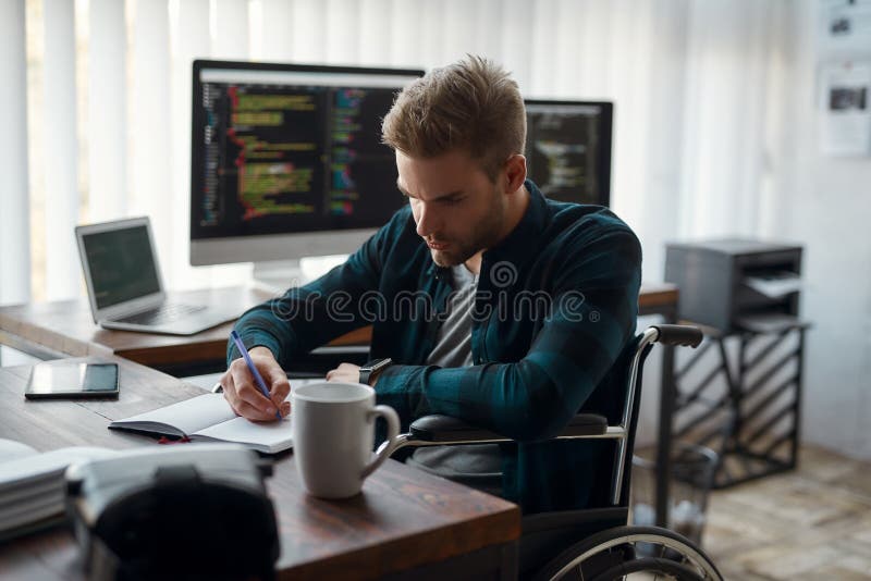 I Can Work with Any Code. Concentrated Male Web Developer in a Wheelchair Writing Program Code ...