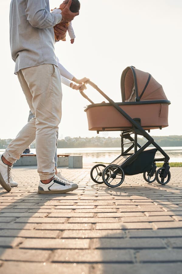 Side View. a Young Couple with a Baby Pram is Walking Together Stock ...