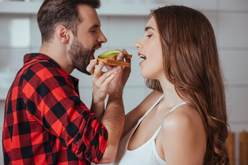 Side View of Young Couple Eating Stock Photo - Image of slices ...