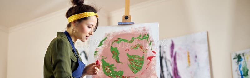 Side View of Young Female Artist in Apron Painting a Picture on Easel ... Side View of Young Female Artist in Apron Painting a Picture on Easel ...