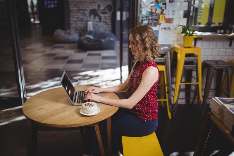 Side View of Young Female Customer Using Laptop while Sitting at Table ...