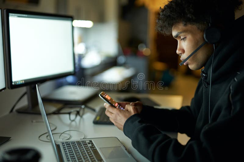Side View of Young Guy Wearing Headset Sitting at the Table in Front of ...