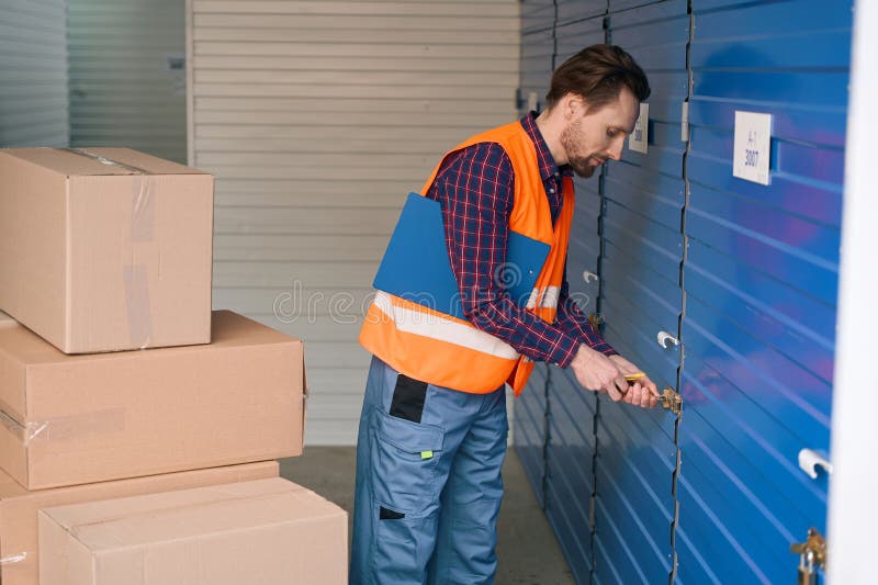 Side View of Young Guy in Work Clothes with Big Cardboard Boxes into ...