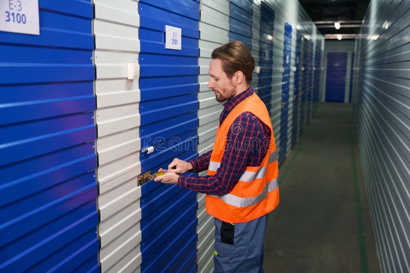 Side View of Young Guy in Work Clothes into Warehouse with Self-storage ...