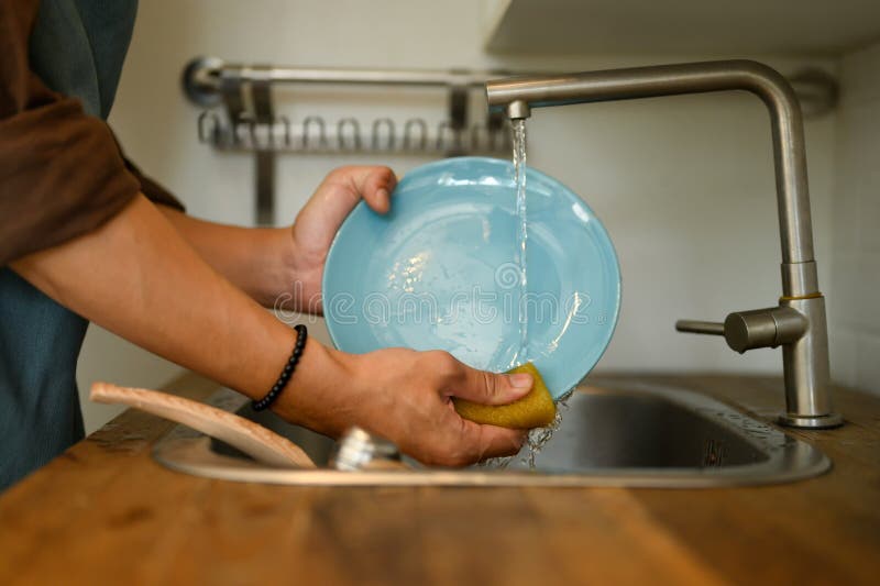 Side View of Young Male Doing Chores, Washing Dishes in the Kitchen ...